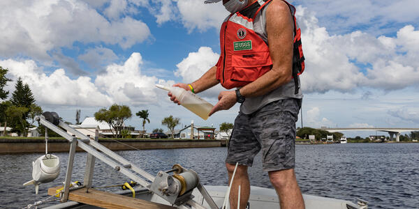 USGS technician holding a bottle containing a sediment sample | U.S ...